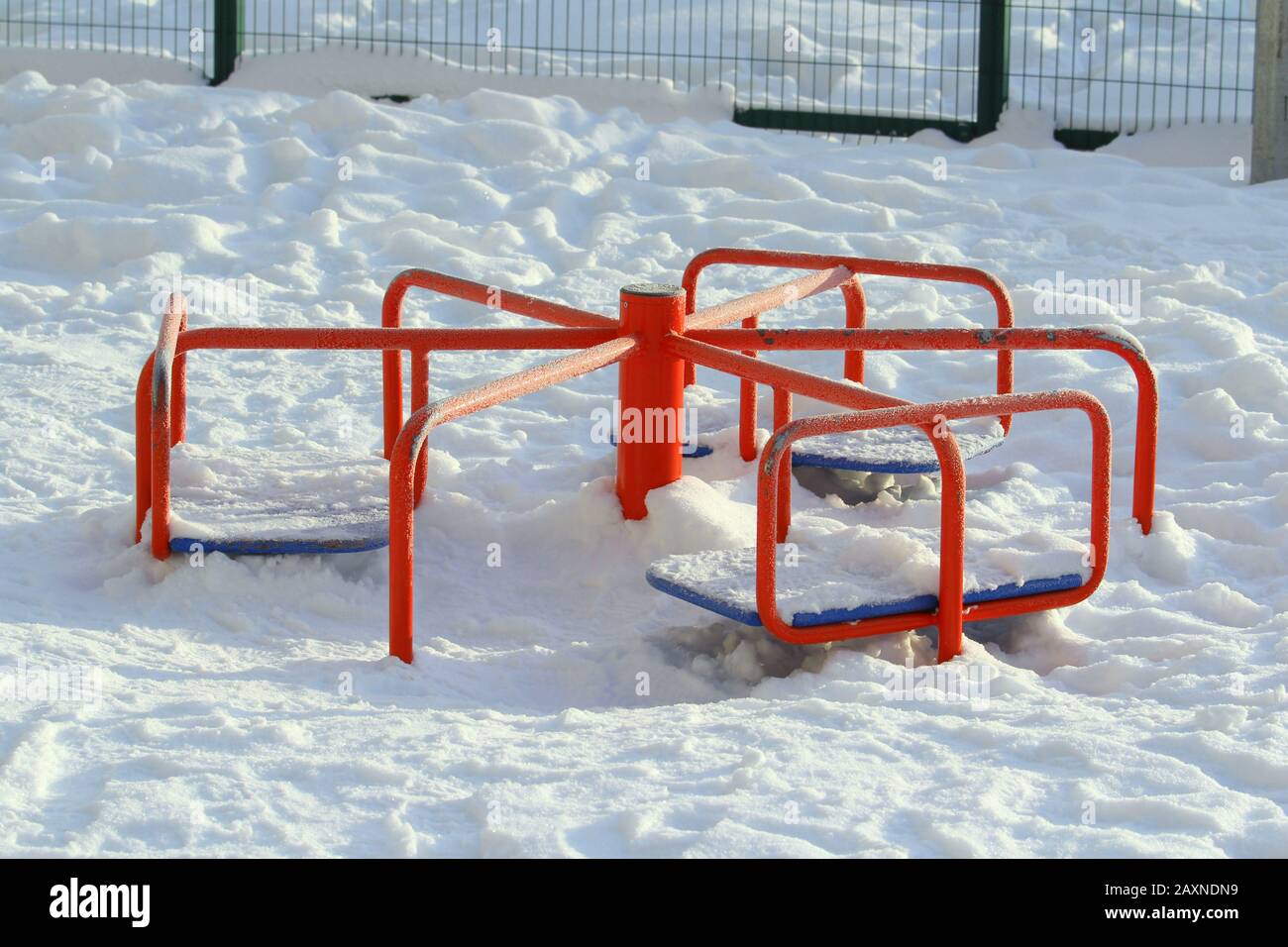 Children's red metal carousel covered with snow. Concept of ...