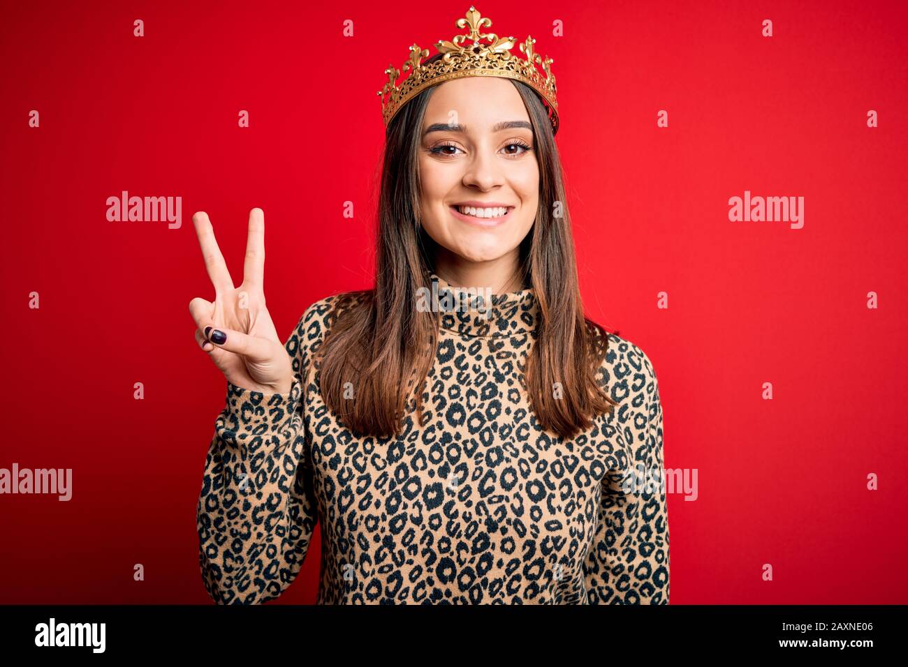 Young beautiful brunette woman wearing golden crown queen over isolated ...