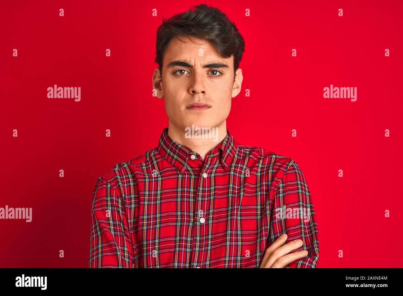 Teenager boy wearing red shirt standing over isolated background ...