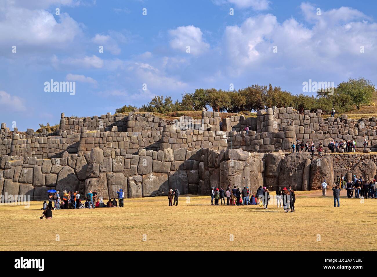 Tourist groups before the ruins with typical stone walls of the Inca's ...
