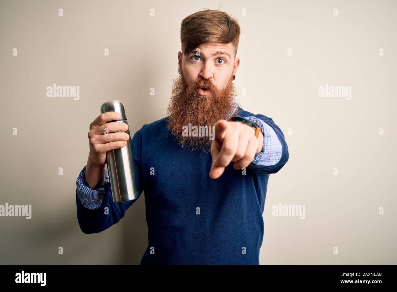 Redhead Irish man with beard holding takeaway beverage thermo over ...