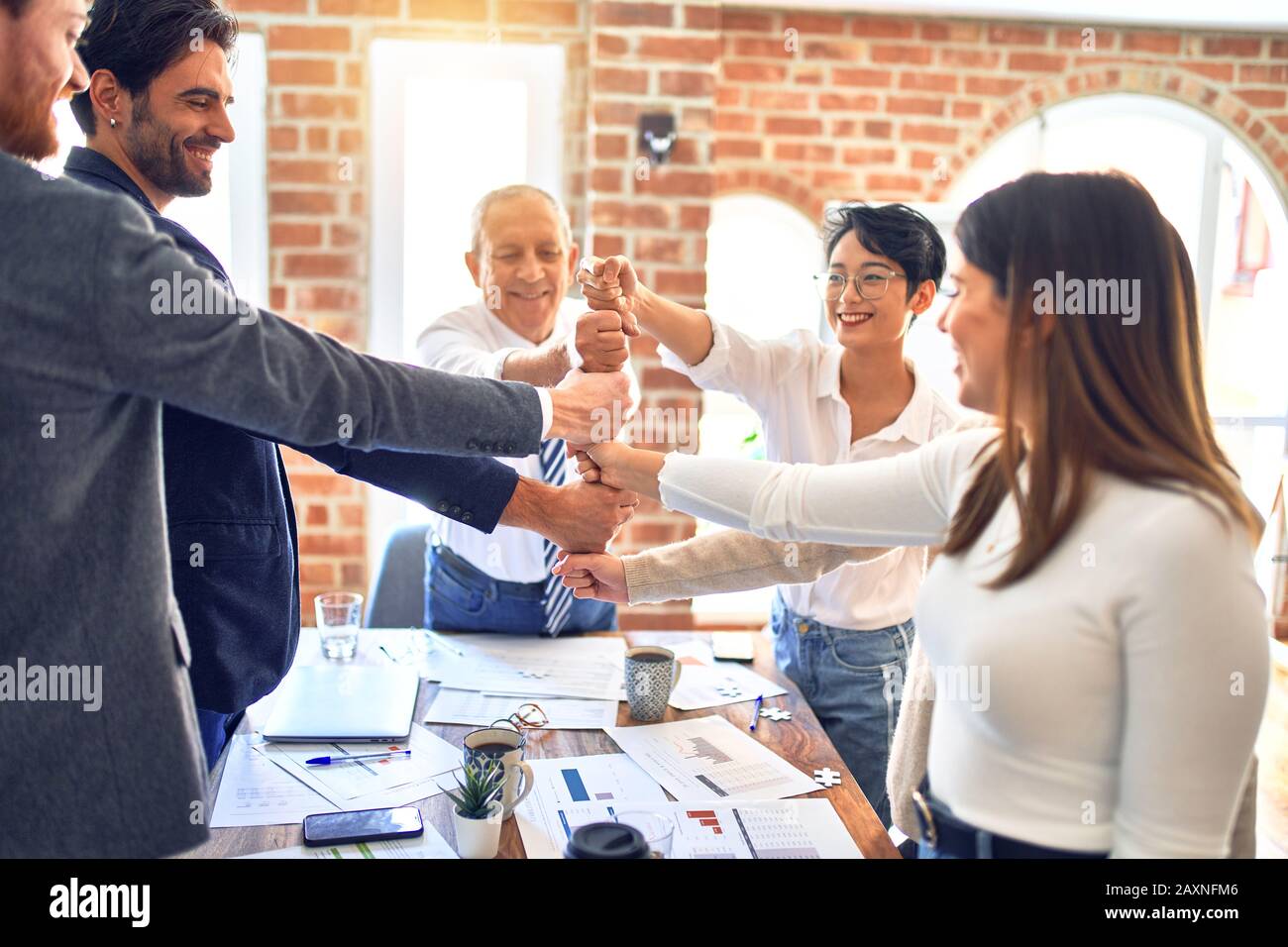 Group of business workers smiling happy. Standing bumping fists at the ...