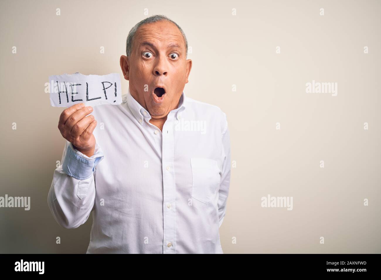 Senior handsome businessman holding paper help message over isolated ...
