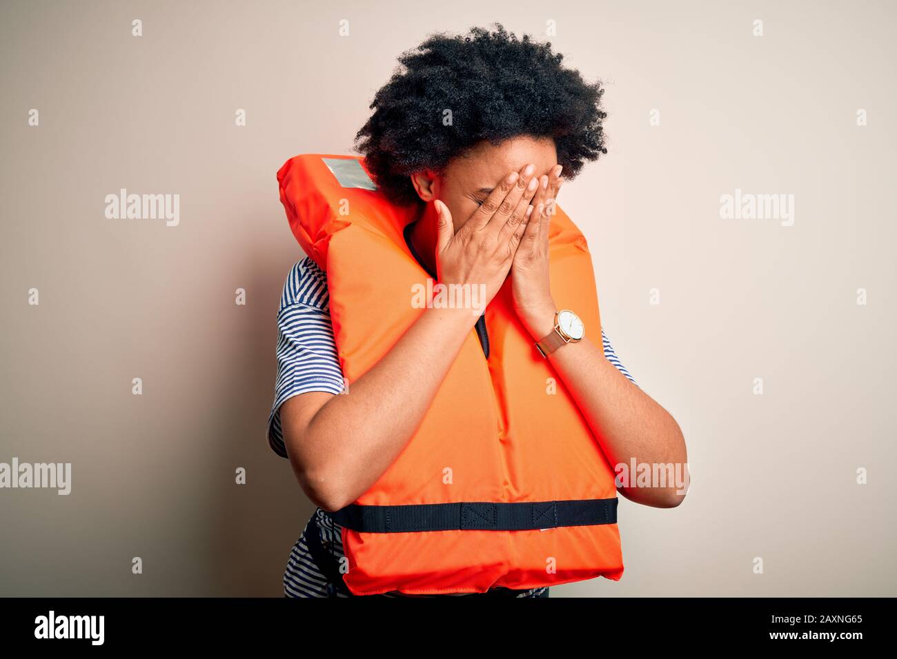 Young African American afro woman with curly hair wearing orange ...