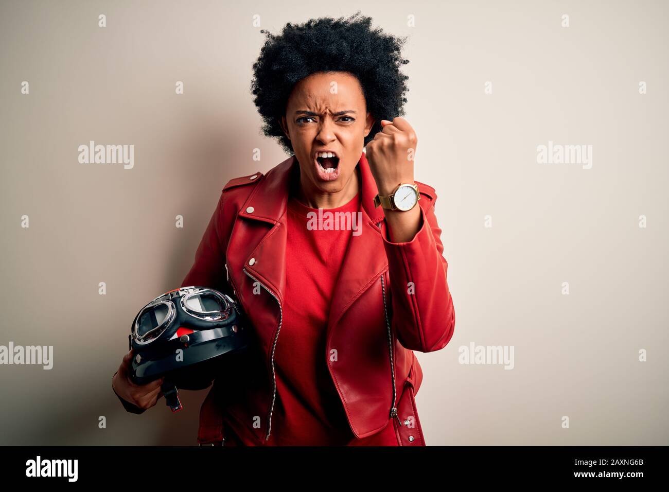 Young African American afro motorcyclist woman with curly hair holding ...