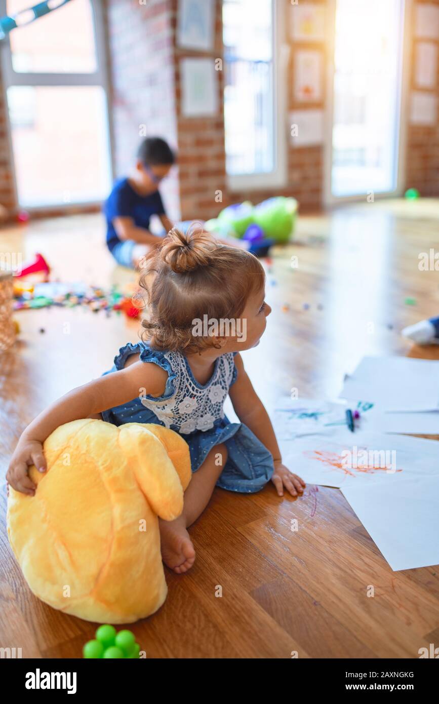 Adorable toddlers smiling happy. Sitting on the floor playing around ...