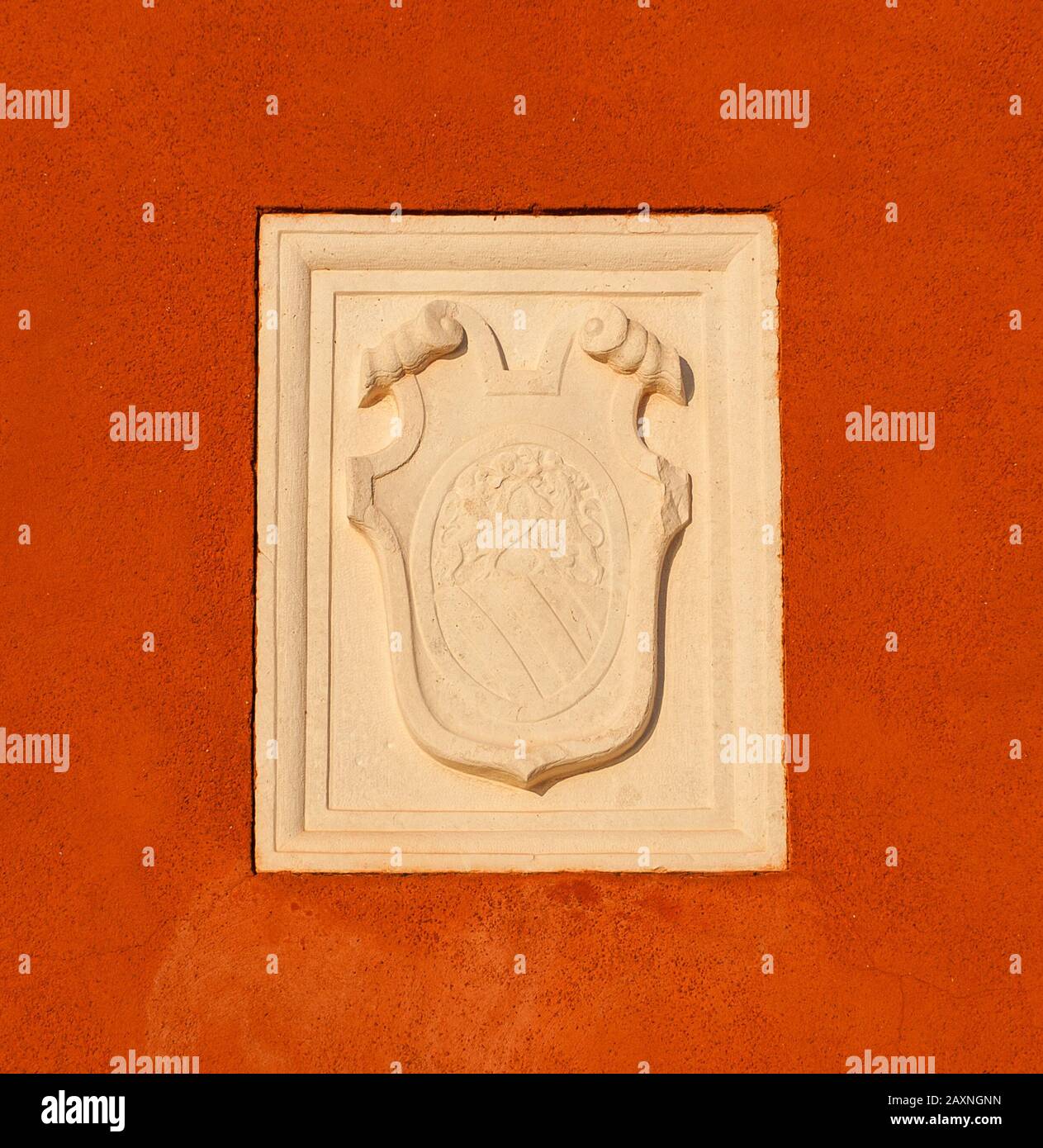 Old heraldic emblem with a damaged relief on a Venice red plaster wall ...