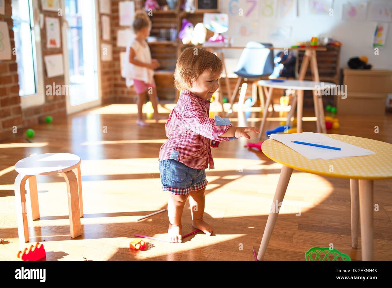 Beautiful toddlers smiling happy playing around lots of toys at kindergarten Stock Photo - Alamy