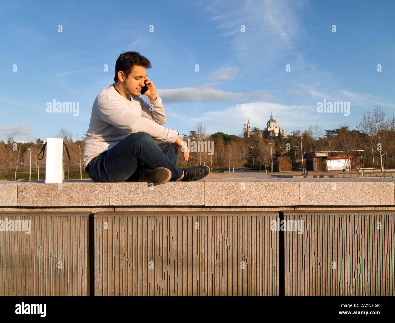 Young handsome caucasian man calling with his phone, seated at Madrid ...