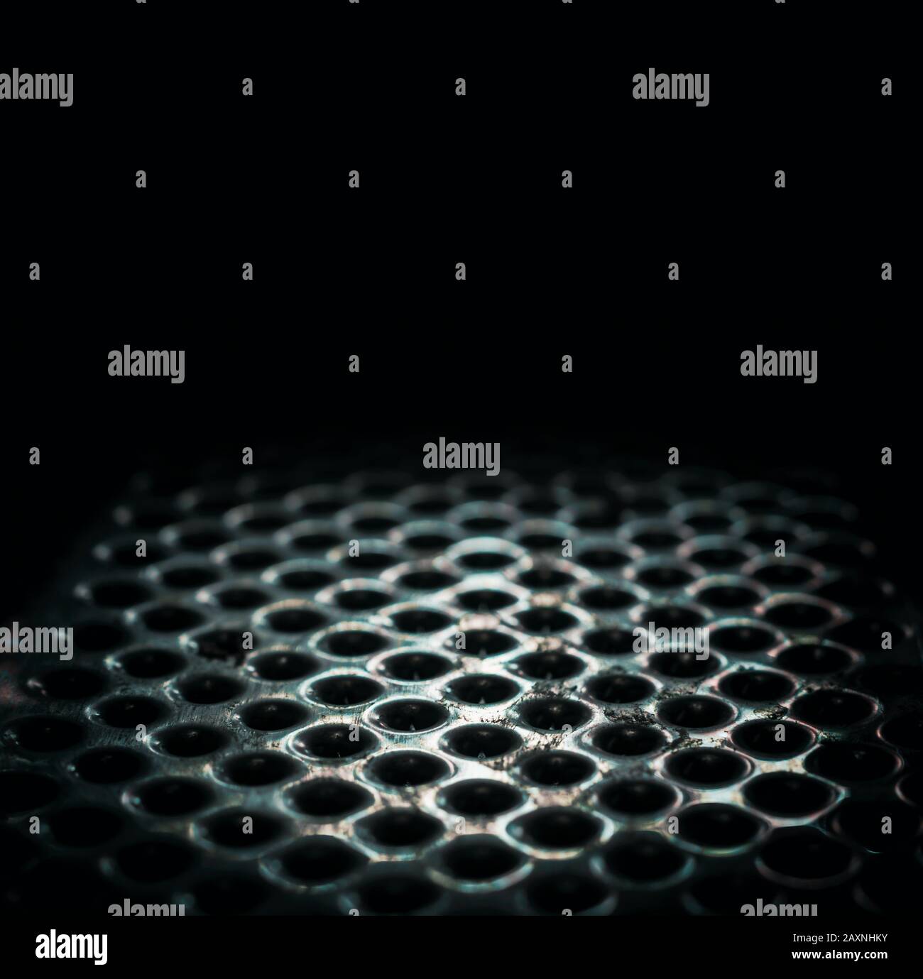 old metal perforated table surface in a dark close up horror background ...