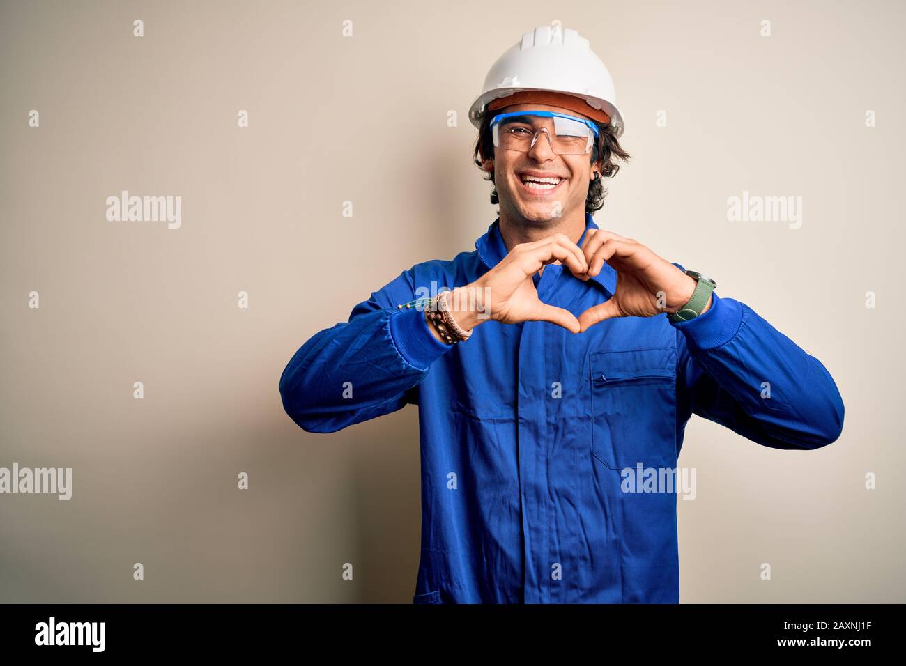 Young constructor man wearing uniform and security helmet over isolated ...