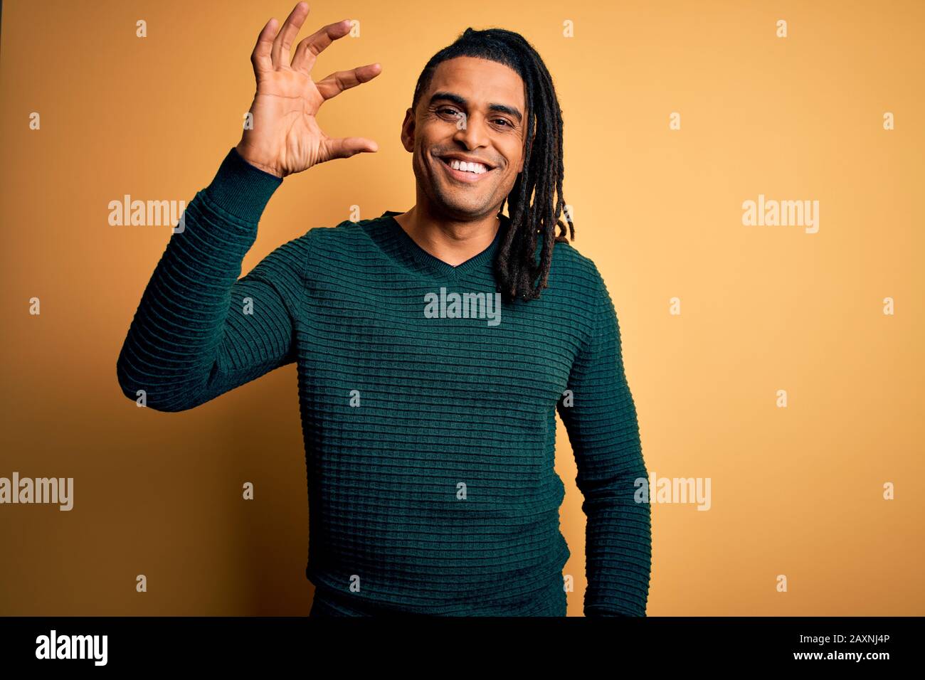 Young handsome african american afro man with dreadlocks wearing green ...