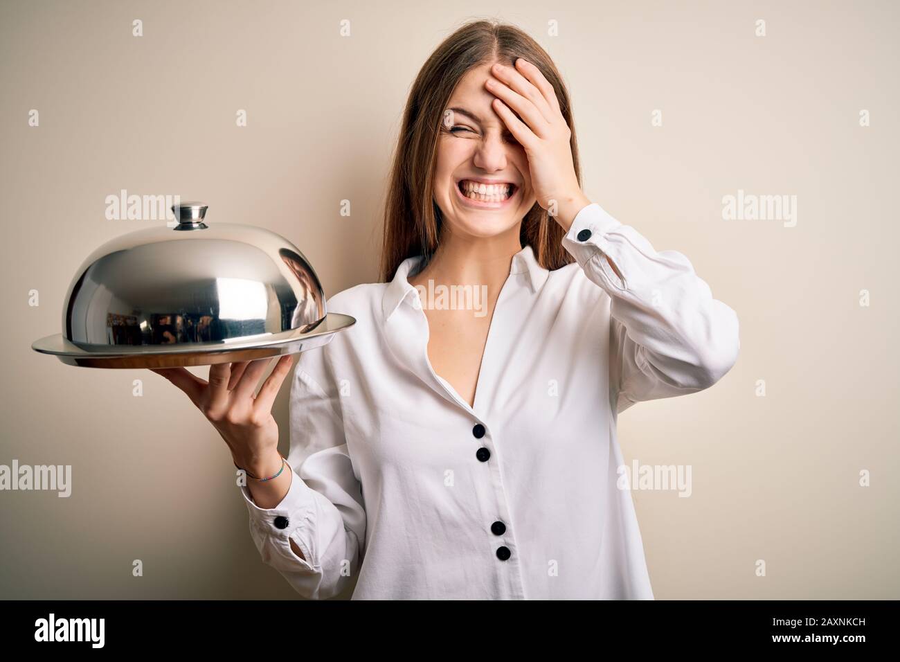 Young beautiful redhead woman holding waitress tray over isolated white ...