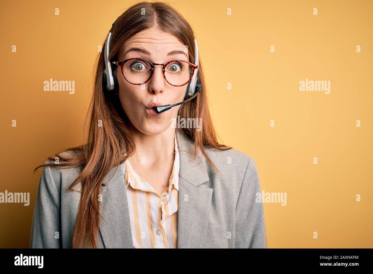 Young redhead call center agent woman overworked wearing glasses using ...