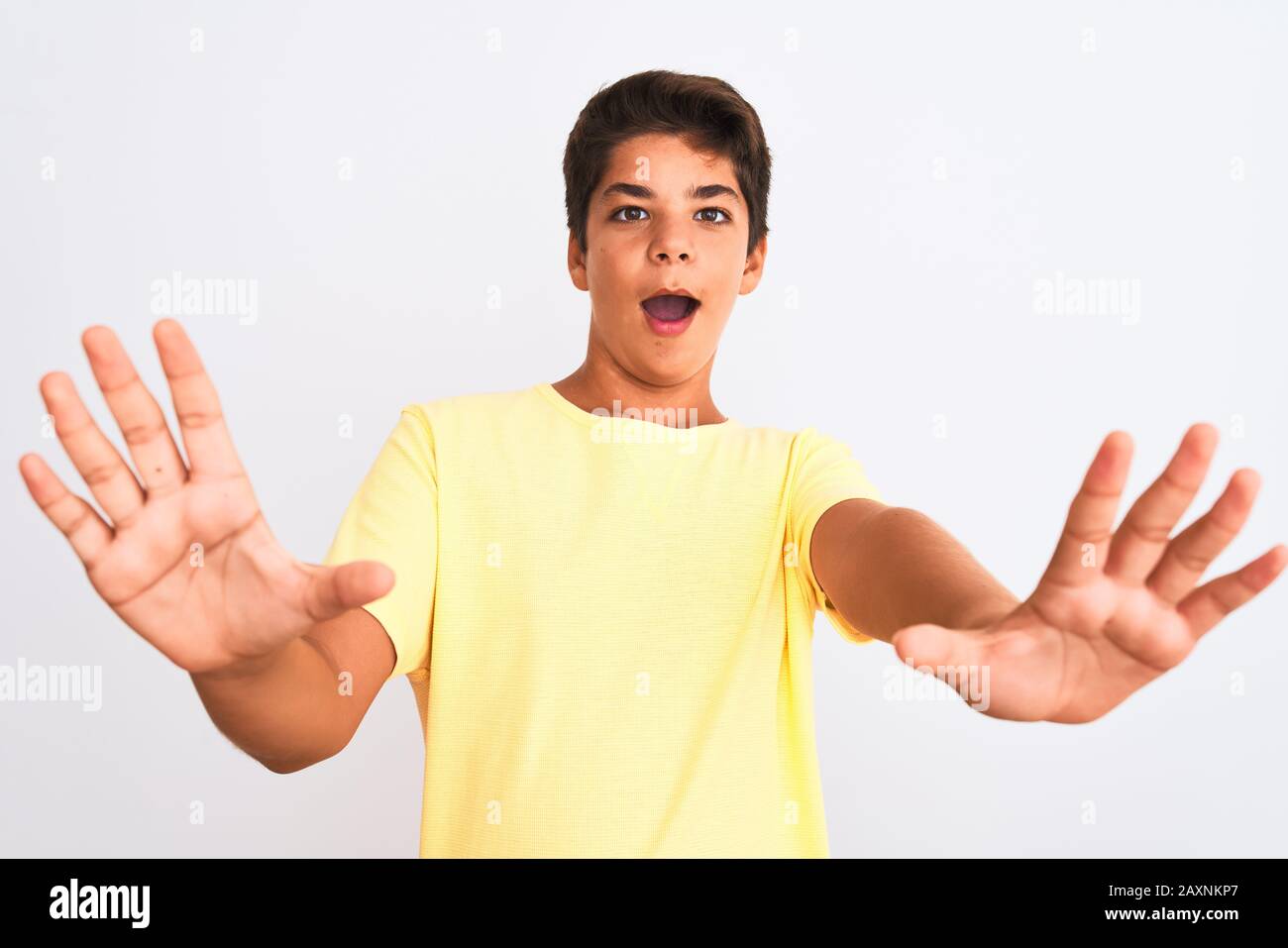 Handsome teenager boy standing over white isolated background afraid ...