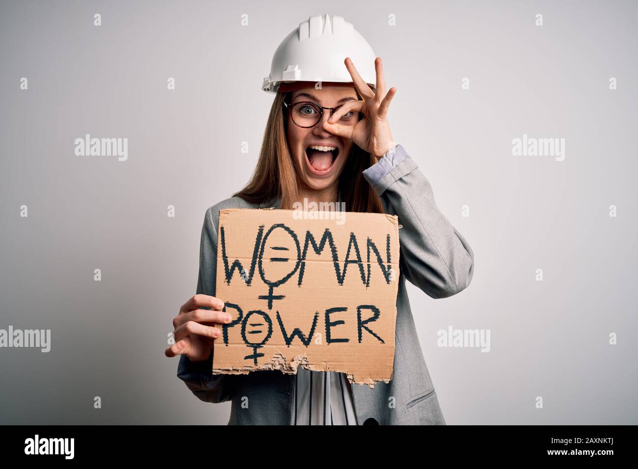 Young redhead architect asking for women rights holding banner with ...