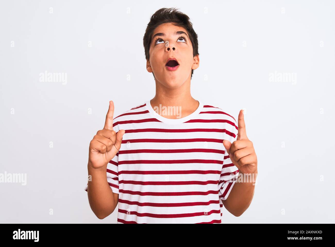 Handsome teenager boy standing over white isolated background amazed ...