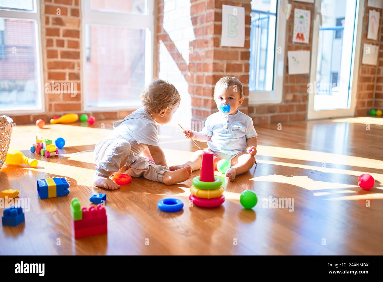 Beautiful toddlers playing around lots of toys at kindergarten Stock ...
