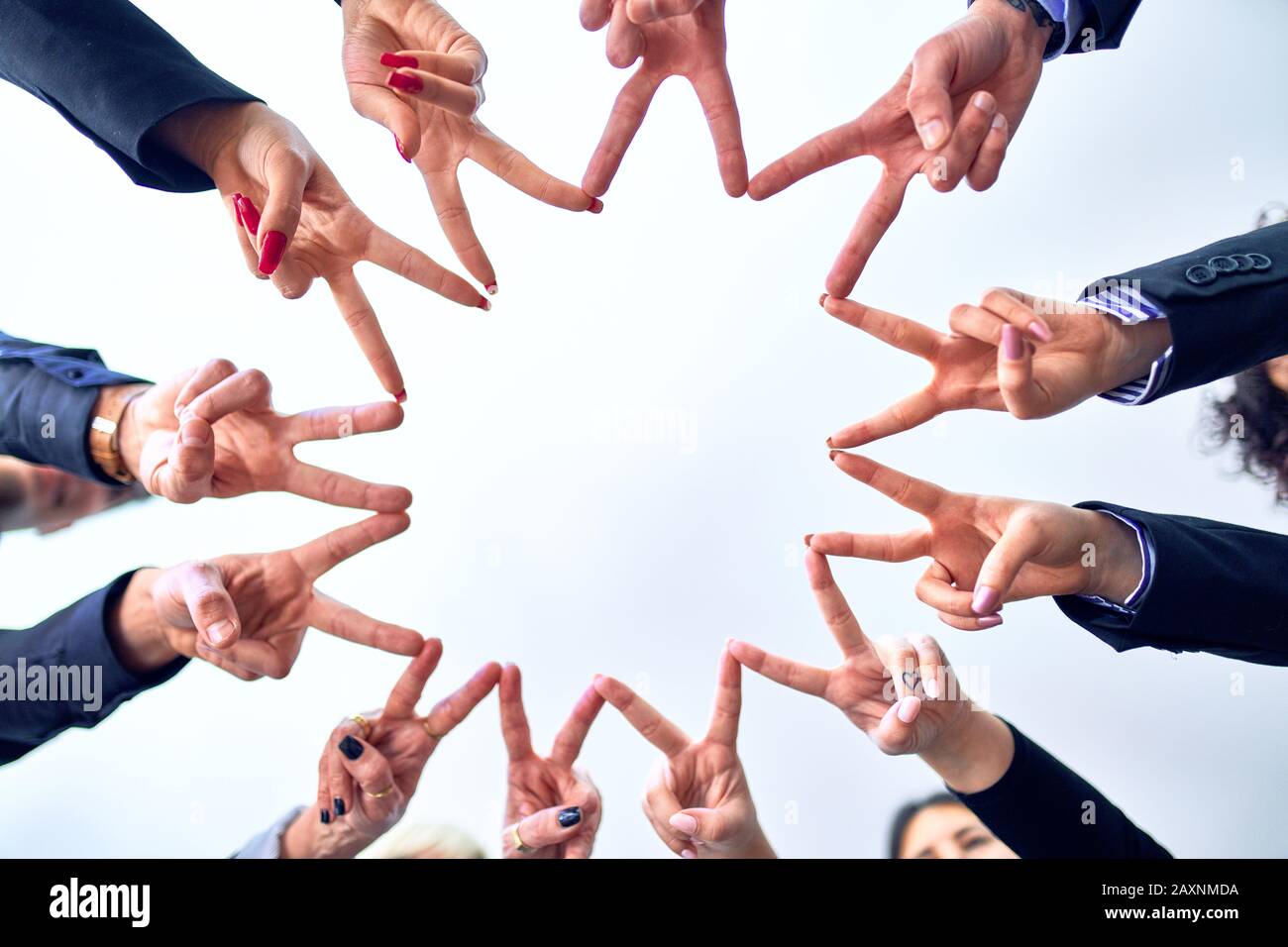 Group of business workers standing doing symbol with fingers together ...