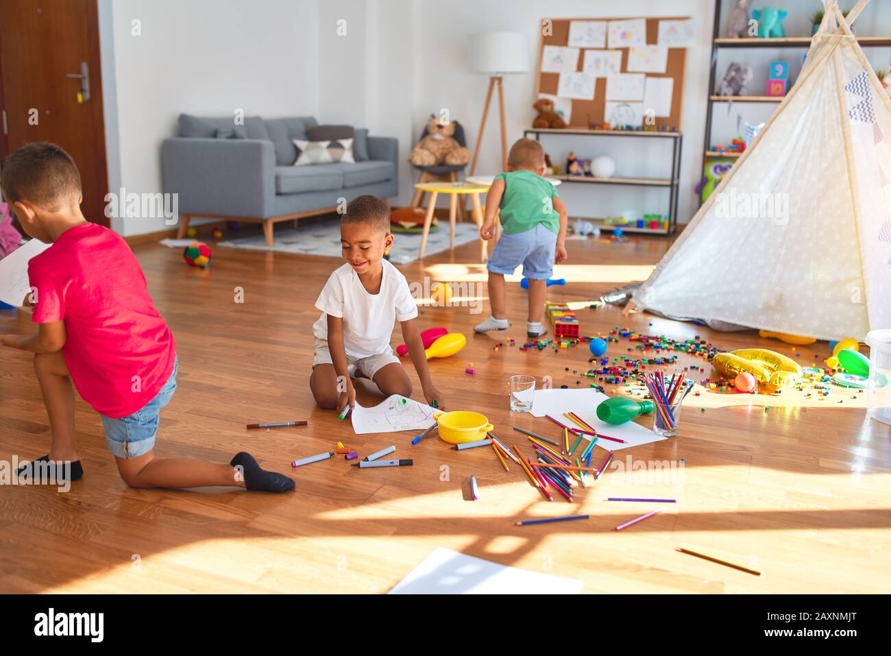 Adorable toddlers playing around lots of toys at kindergarten Stock ...