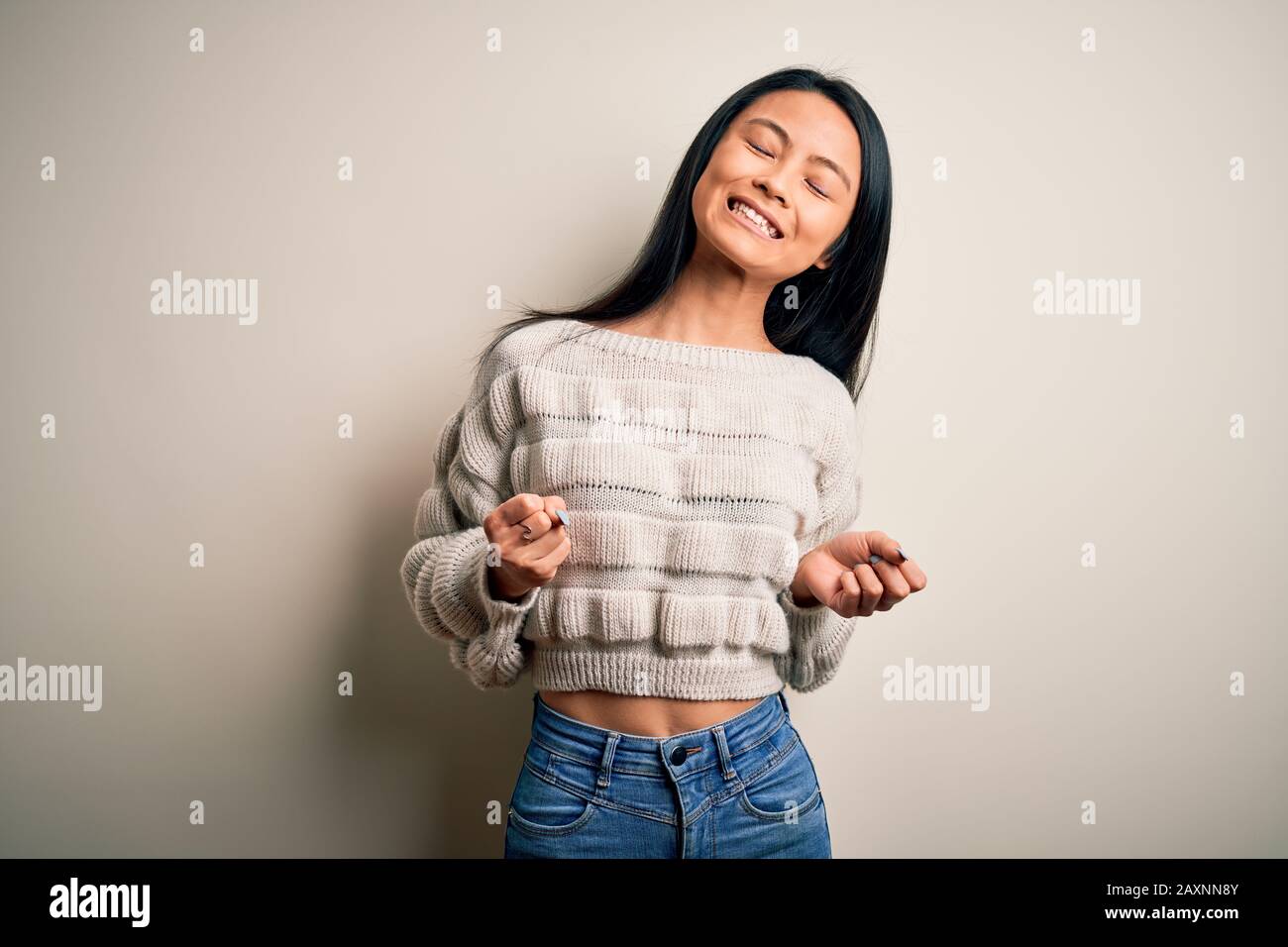 Young beautiful chinese woman wearing casual sweater over isolated ...
