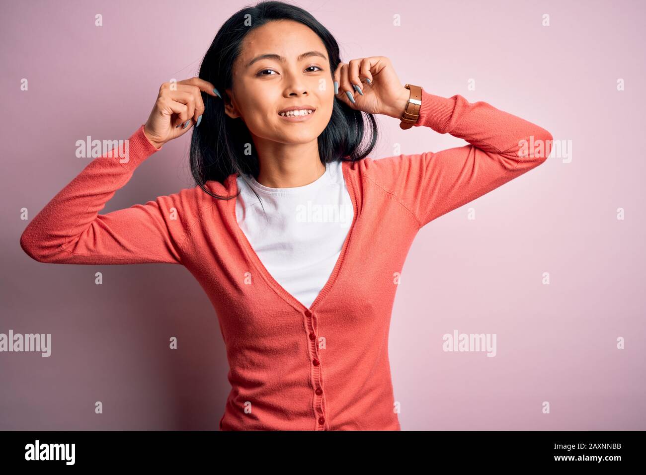 Young beautiful chinese woman wearing casual sweater over isolated pink ...