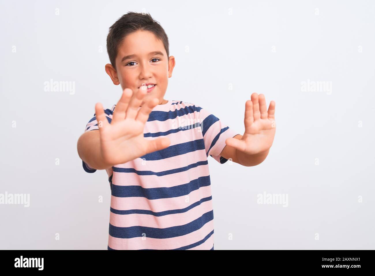 Beautiful kid boy wearing casual striped t-shirt standing over isolated ...
