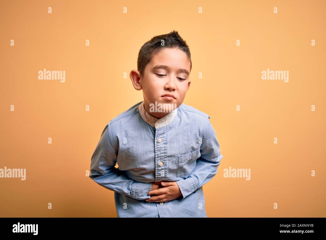 Young little boy kid wearing elegant shirt standing over yellow ...