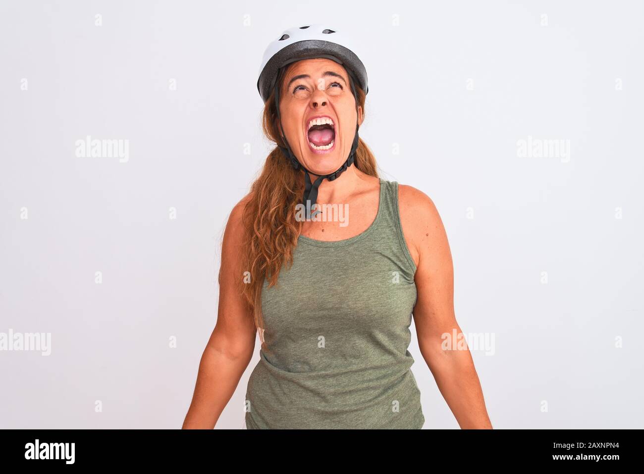Middle age mature cyclist woman wearing safety helmet over isolated ...