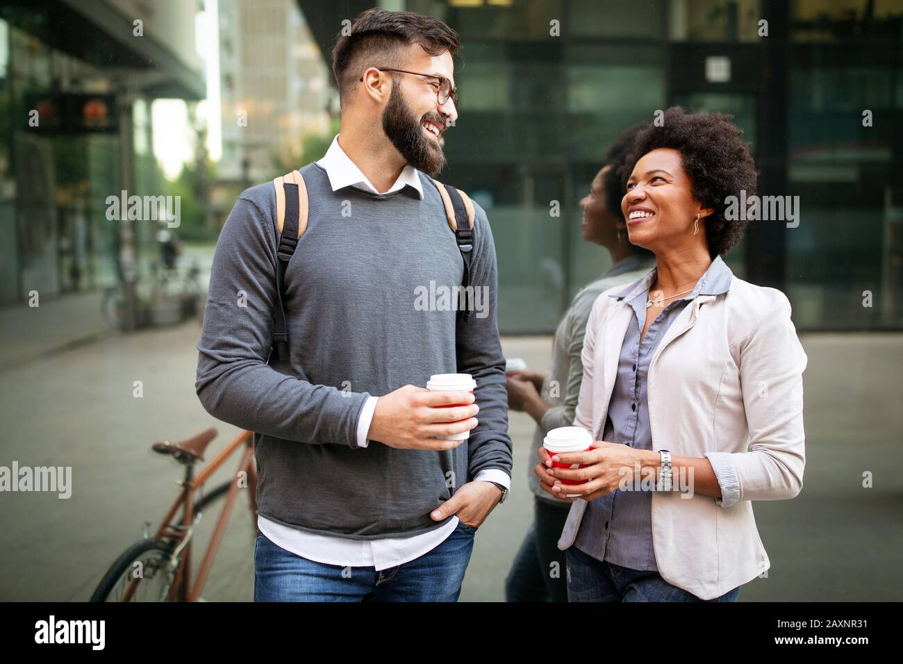 Business people discussing and smiling while walking together outdoor ...