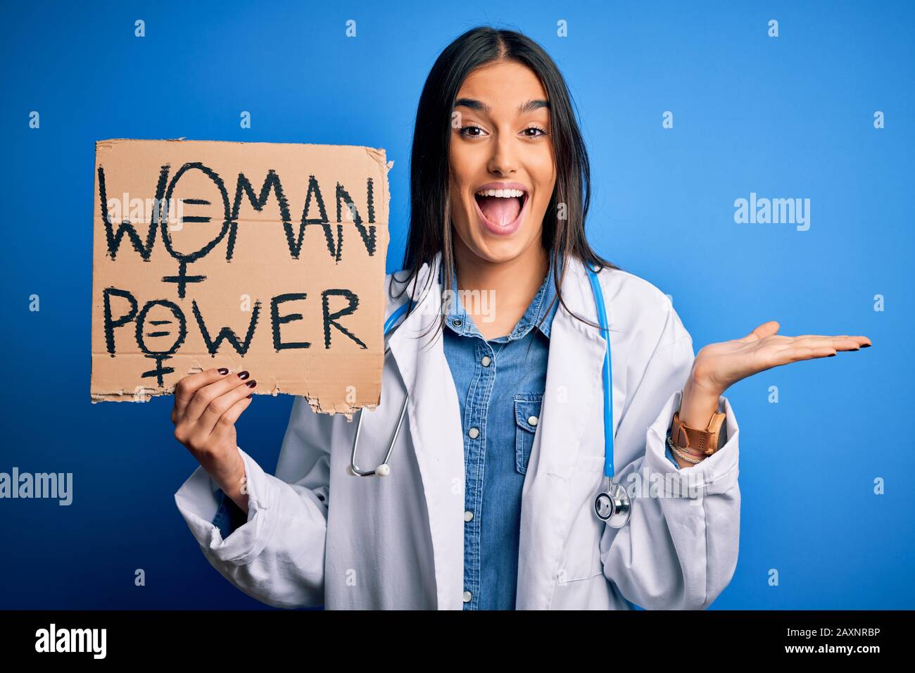 Young doctor woman wearing stethoscope holding cardboard banner with ...