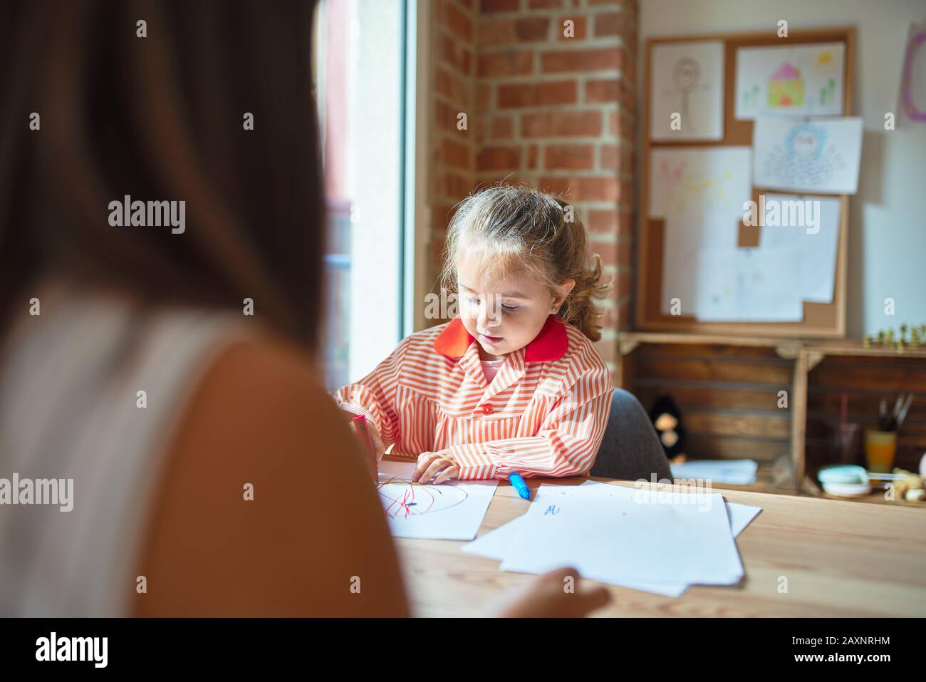 Beautiful teacher and blond student toddler girl wearing school uniform ...