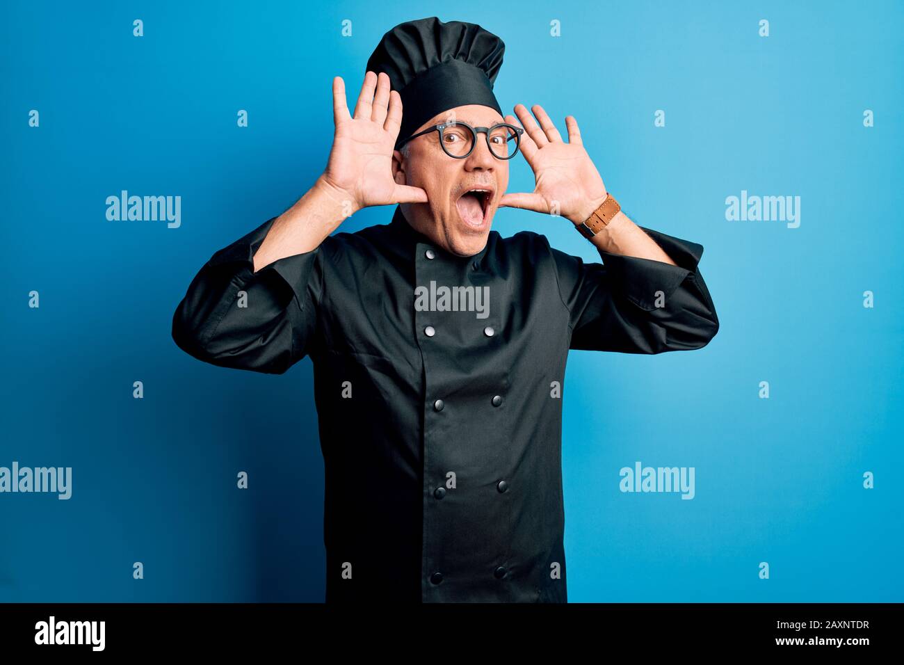 Middle age handsome grey-haired chef man wearing cooker uniform and hat ...