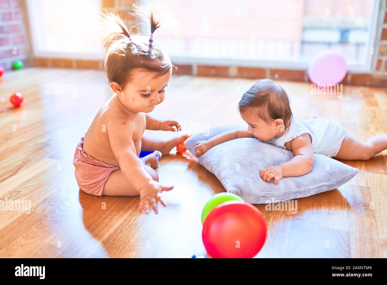 Beautiful infant happy girls playing together at home kindergarten ...