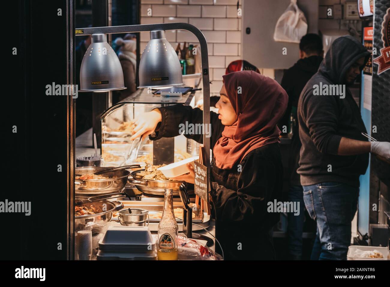 London, UK - November 26, 2019: Muslim woman in hijab cooking at a ...