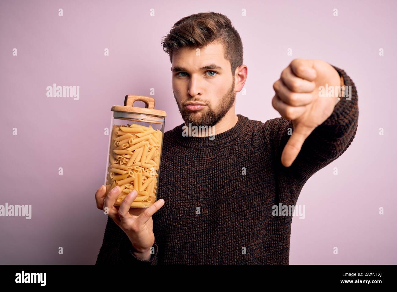 Young blond man with beard and blue eyes holding bottle of Italian dry ...