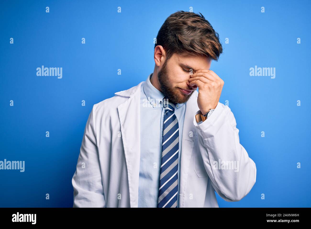 Young blond therapist man with beard and blue eyes wearing coat and tie ...