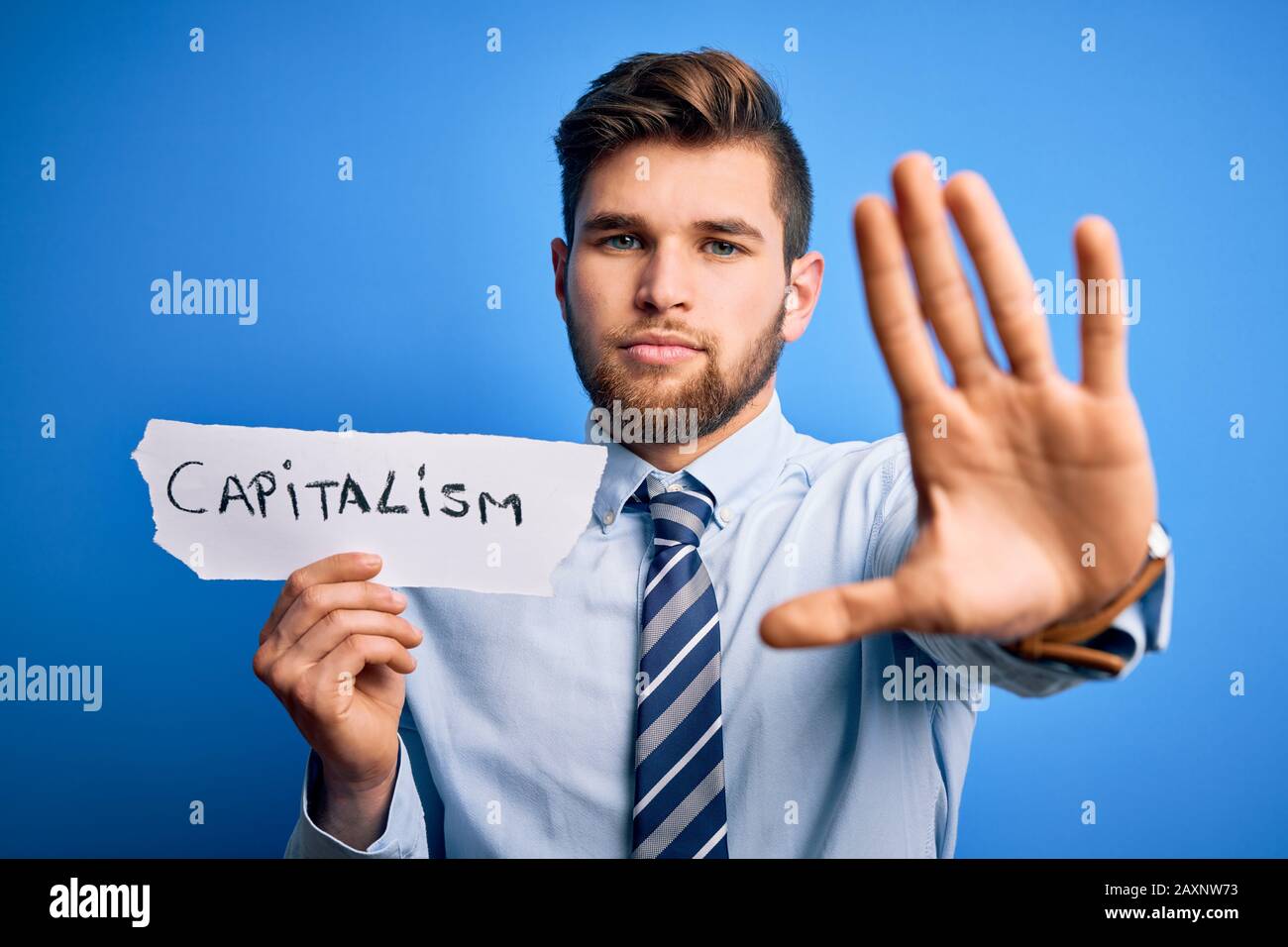 Young blond businessman with beard and blue eyes holding paper with ...