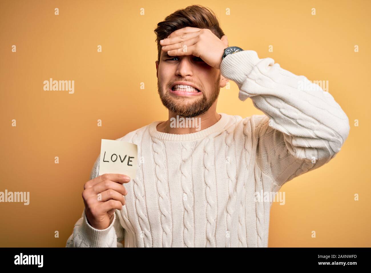 Young Blond Romantic Man With Beard And Blue Eyes Holding Paper With Love Message Stressed With