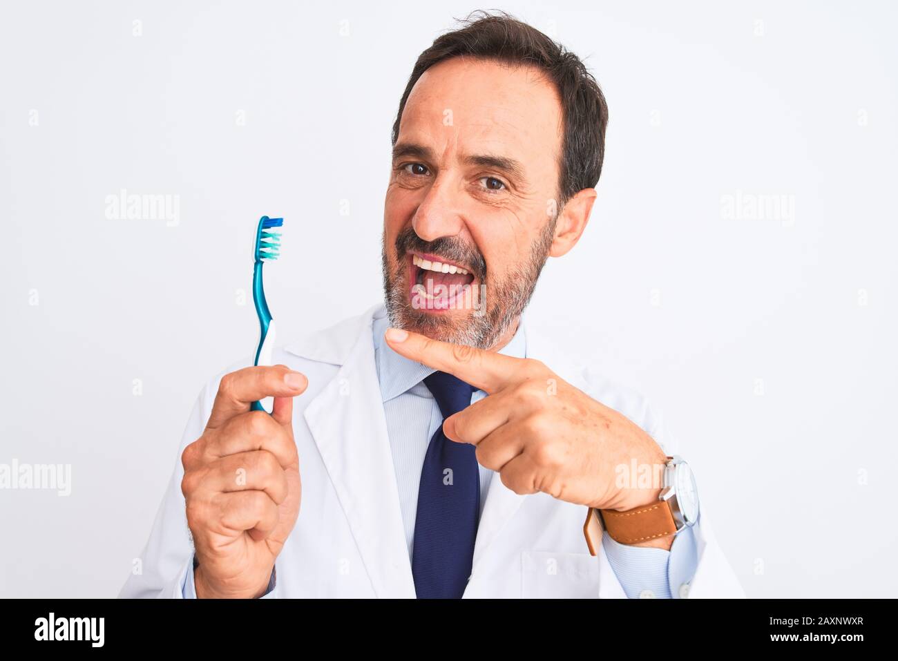 Middle age dentist man holding toothbrush standing over isolated white ...
