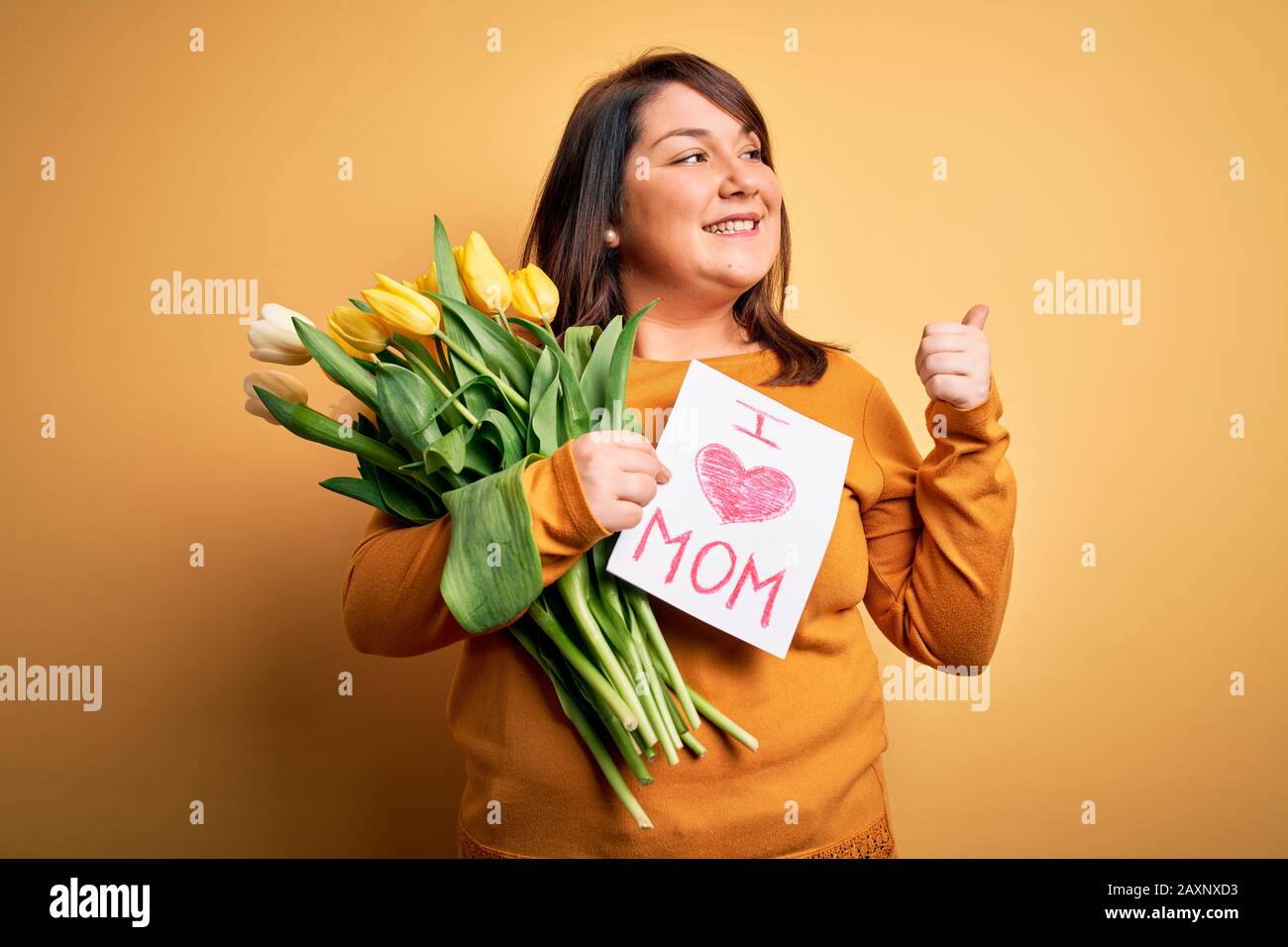 Young beautiful plus size woman celebrating mothers day holding love ...
