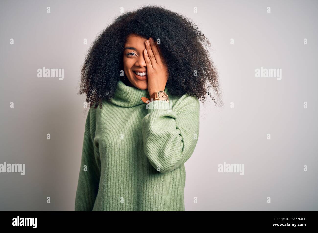 Young beautiful african american woman with afro hair wearing green ...