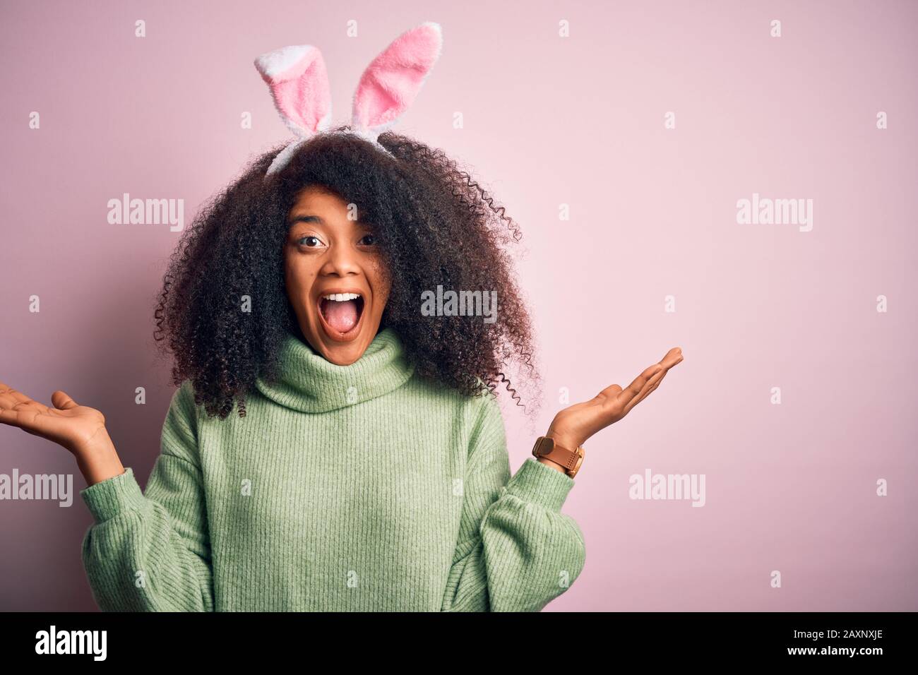 Young african american woman with afro hair wearing easter rabbit ears ...