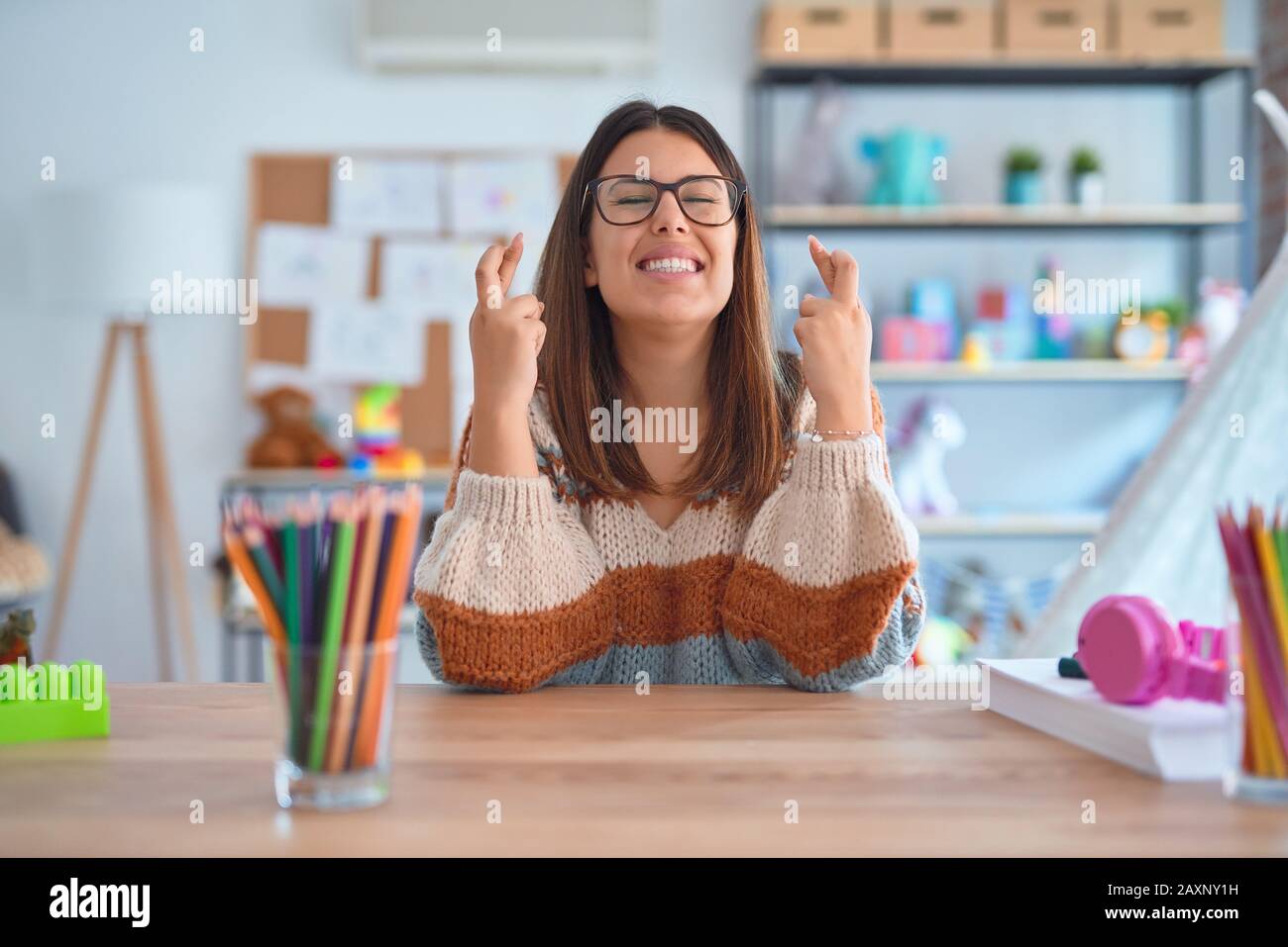 Young beautiful teacher woman wearing sweater and glasses sitting on ...