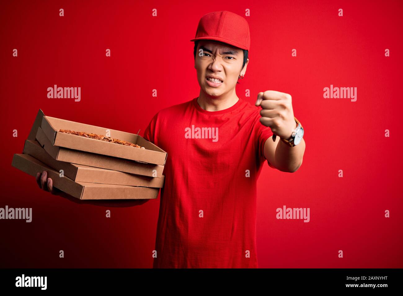 Young handsome chinese delivery man holding deliver boxes with Italian ...