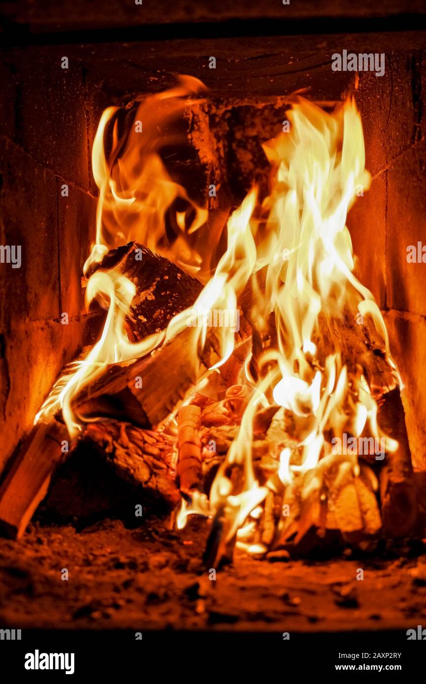 bright flame of fire burns in a fireplace in the old house in winter ...