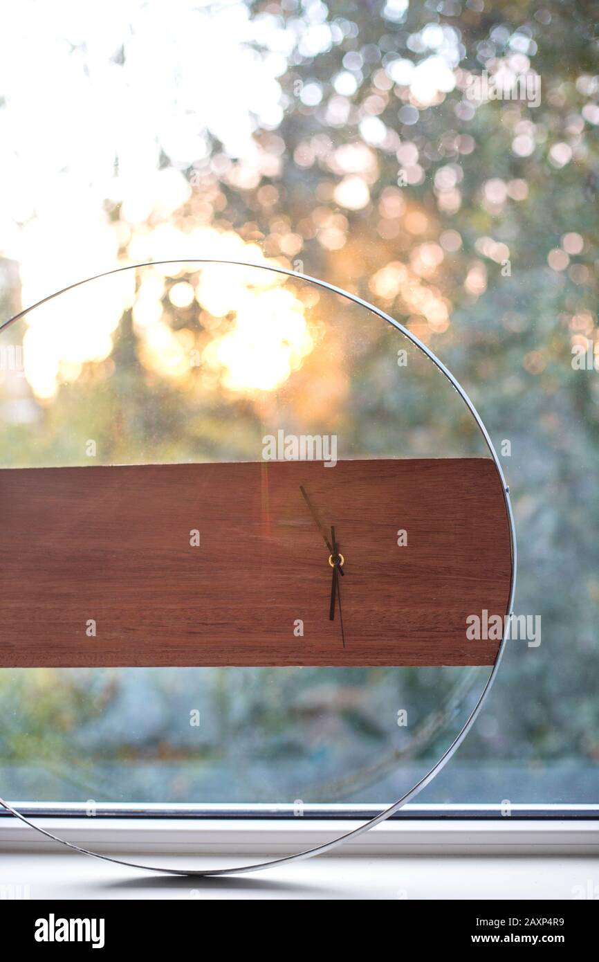 Wall clock leaning against windowpane Stock Photo - Alamy