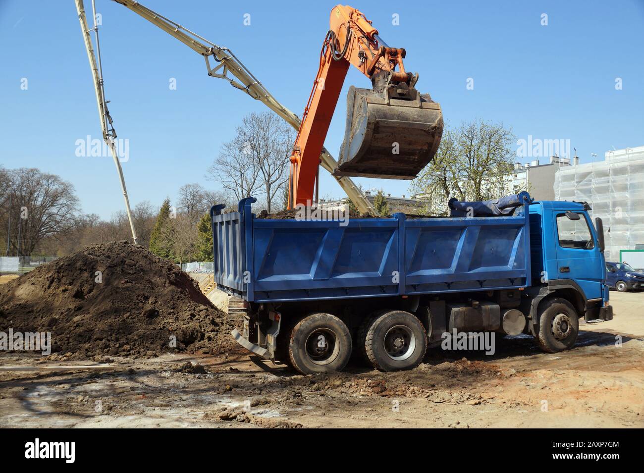 Excavator loading the ground for a tipper truck. Pouring concrete in ...