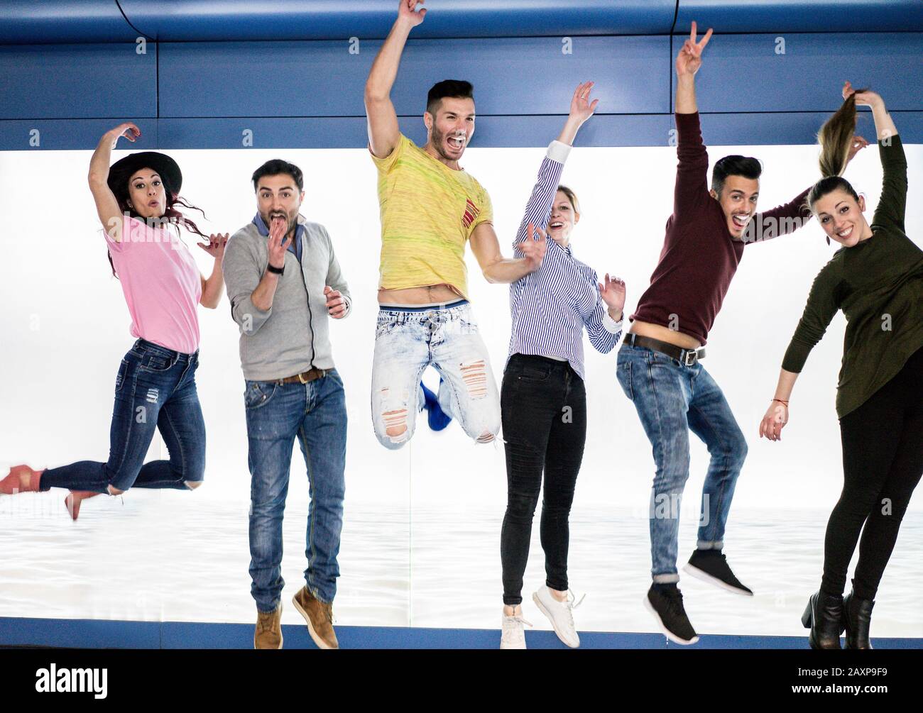 Group of happy friends jumping in underground metro station - Young ...
