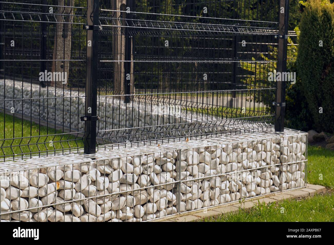 A low foundation under a steel openwork fence. Gabion Stock Photo - Alamy